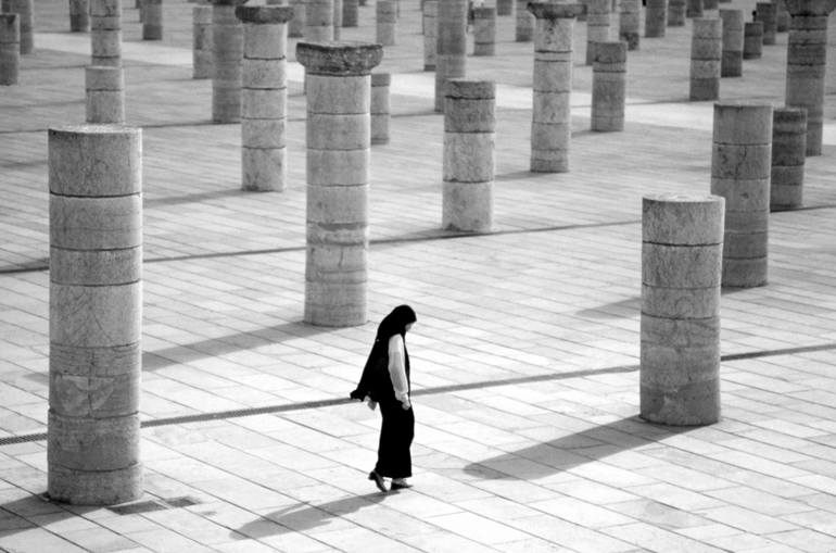 Woman walking amongst the columns of the Yacoub El Mansour mosque ...